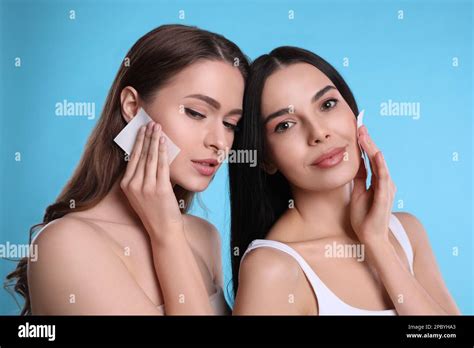 Beautiful Women Using Mattifying Wipes On Light Blue Background Stock