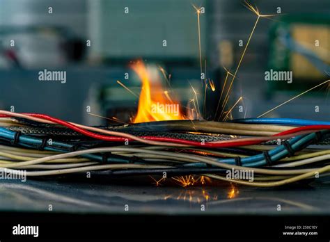 Flames, sparks, smoke between electrical cables, close up. Short circuit in the twisted wires ...