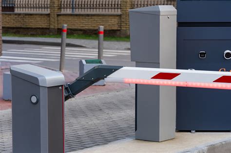 주차장 입구에는 자동 보안 장벽이 단단히 서 있어 차량 접근을 통제할 수 있습니다 빨간색 표시등은 진입이 제한되어 안전 프로토콜을 강화한다는 것을 나타냅니다 0명에 대한
