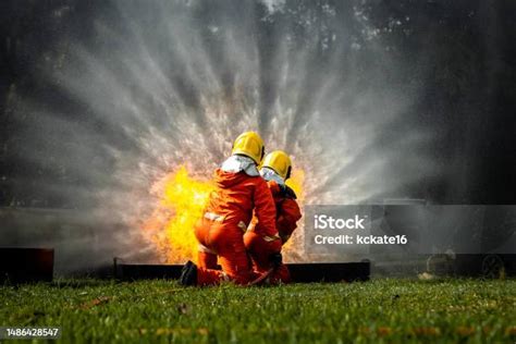 소방관 개념 화재로 싸우기 위해 물과 소화기를 사용하는 소방관 소방 훈련 훈련 중 호스와 물로 화재와 싸우는 소방관 2명에 대한 스톡 사진 및 기타 이미지 Istock
