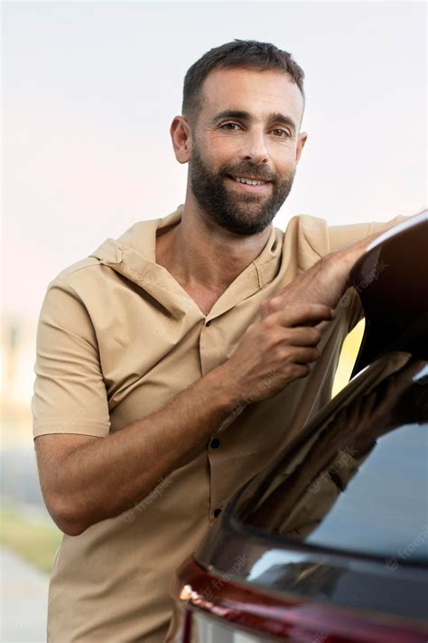 Premium Photo Smiling Bearded Latin Man Standing Near New Car Looking