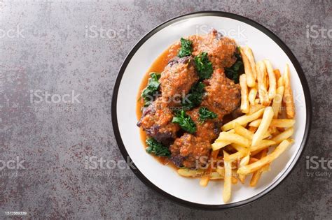 맛있는 라보 데 토로 또는 소꼬리 스튜는 테이블에 흰색 접시에 감자 튀김과 함께 제공됩니다 수평 상단 보기 감자 요리에 대한