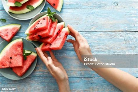 복사 공간이있는 파란색 소박한 나무 배경에 여성의 손에 신선한 붉은 수박 슬라이스 수박 슬라이스와 민트를 배경으로 합니다 위쪽 보기 0명에 대한 스톡 사진 및 기타 이미지