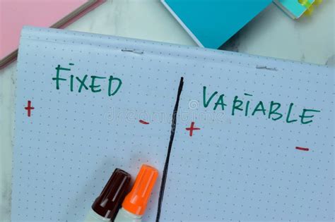 Concept Of Fixed And Variable Write On Book Isolated On Wooden Table