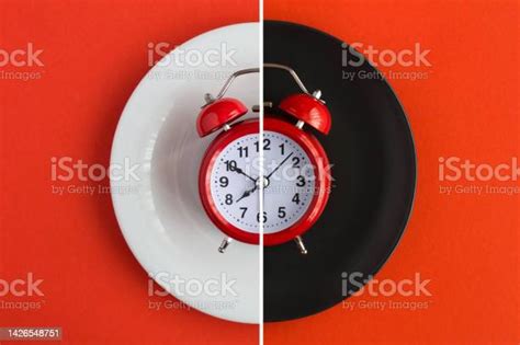 빨간색과 검은 색 배경의 흰색 접시에 빨간색 알람 시계의 콜라주 상단 보기 클로즈업 시침에 대한 스톡 사진 및 기타 이미지