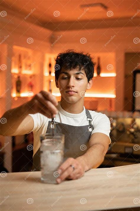 Bartender Is Stirring Cocktail On Bar Counter With Special Spoon Stock