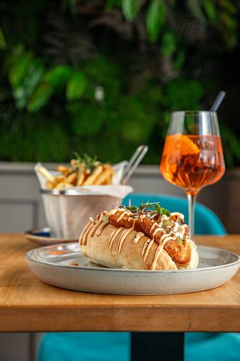 레스토랑 테이블에 치폴레 소스를 곁들인 프라이드 치킨 샌드위치 롤빵과 음료와 감자튀김 핫도그에 대한 스톡 사진 및 기타 이미지 핫도그 0명 감자 요리 Istock