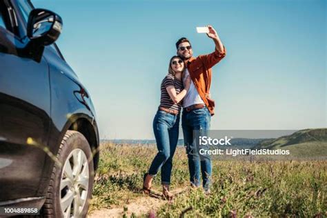 세련 된 남자 시골 풀밭에 차 근처 여자 친구와 함께 Selfie를 복용 관광에 대한 스톡 사진 및 기타 이미지 관광