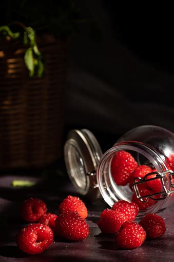 어두운 배경에 민트 잎 옆에 흩어져 있는 라즈베리의 수직 클로즈업 이미지 라즈베리에 대한 스톡 사진 및 기타 이미지 라즈베리 감귤류 과일 개념 Istock