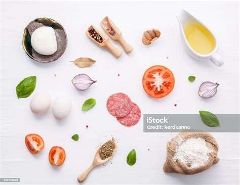 재료 달콤한 바 질 토마토 마늘 베이 잎 후추 양파 모 짜 렐 라 치즈 평면 흰색 나무 배경에 수 제 피자 재료 하다 건강에
