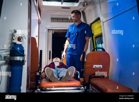 Corpsman In Blue Uniform Stand Beside Senseless Woman Lying On