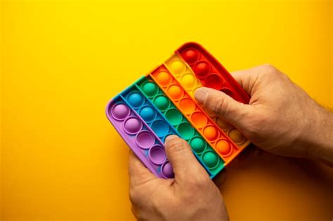 Premium Photo A Mans Hand Presses On A Rainbow Silicone Antistress