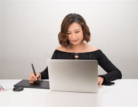 Young Asian Female Designer Using Graphics Tablet While Working With Computer Stock Image