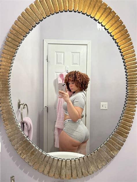 A Pregnant Woman Taking A Selfie In Front Of A Mirror With Her Cell Phone