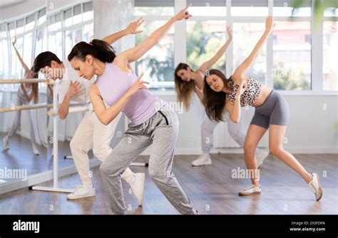 Cheerful Young Girl And Multinational People Training Synchronous Group