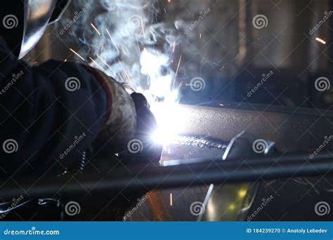 A Highly Skilled Welder Welds A Metal Structure At An Assembly Plant
