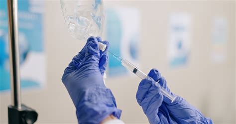 의료 약용 주사기가 있는 간호사의 Iv 드립 및 손 환자를 위한 주입 및 약물 용량 병원 진료소와 치료 질병 및 의료용 액체를