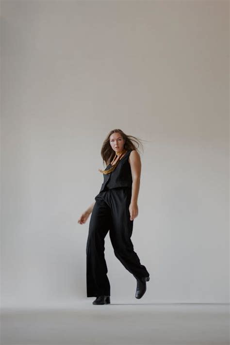 걷고 있는 검은 옷 검은 조끼 균형 뉴트럴 톤 다이나믹한 런웨이 매끄러운 모델 미니멀리스트 수직 쐈어 스타일 스타일 촬영 스튜디오 촬영 여성