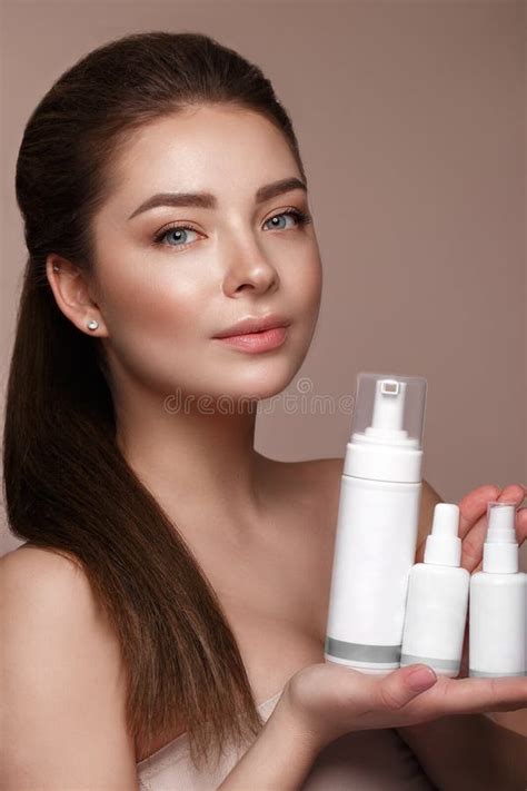 Beautiful Young Girl With Natural Nude Make Up With Cosmetic In Hands