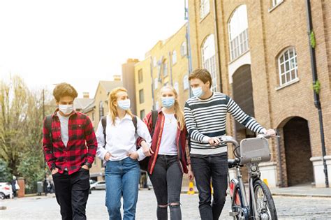 얼굴 마스크를 쓰고 도시에서 걷는 십대 친구 그룹 코로나 바이러스 동안 런던에서 함께 시간을 즐기는 십대 의 다인종 그룹 런던의