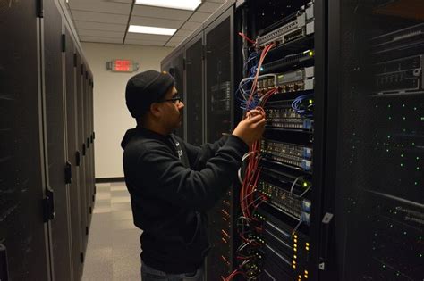 Technician Installing A Server Rack Mounted Environmental Alarm System