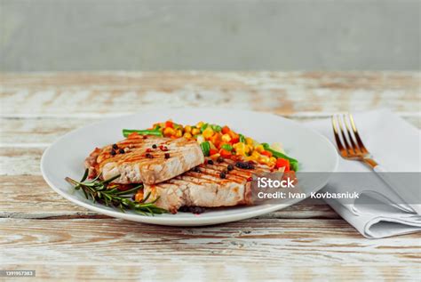 구운 고기 조각 로즈마리와 후추를 화이트 플레이트에 곁들인 스테이크 흰색 나무 테이블에 붉은 소스와 고기 요리 스테이크 근처의