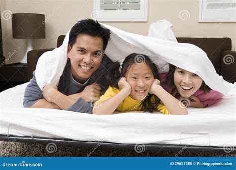 Familia Que Oculta Debajo De La Manta Foto De Archivo Imagen De