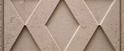 금이 간 분홍색 페인트 클로즈업이 있는 옛 소련 콘크리트 울타리의 간단한 조각 기하학적 도형이 있는 오래된 필링 울타리의 최소 배경 특이한 디자인의 분홍색 울타리가 있는