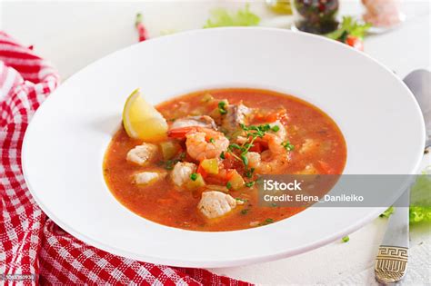 브라질 음식 생선 및 흰색 나무 테이블에 접시에 매운 코코넛 소스에 피망 Moqueca Capixaba 브라질 생선 스튜