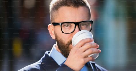 힙스터 사업가가 일회용 컵을 들고 커피를 마시고 검은 안경을 쓰고 런던 거리를 걷고 있다 사진 Unsplash의 걷기 이미지