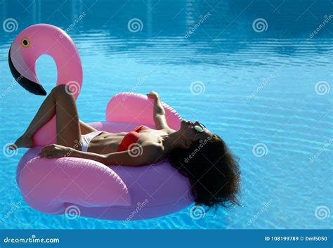 Woman In A Swimming Pool Leisure On A Giant Inflatable Giant Pink