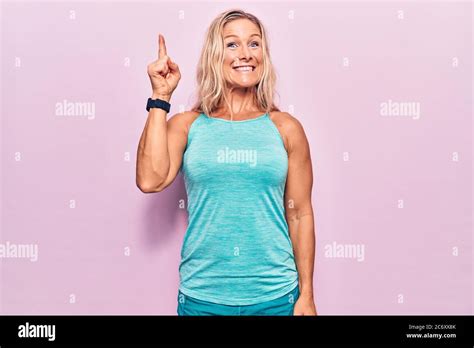 Middle Age Caucasian Blonde Woman Wearing Sports Clothes Over Pink