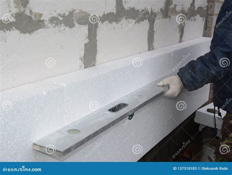 Builder Install Styrofoam Insulation Board And Measuring With Spirit Level Exterior Foam