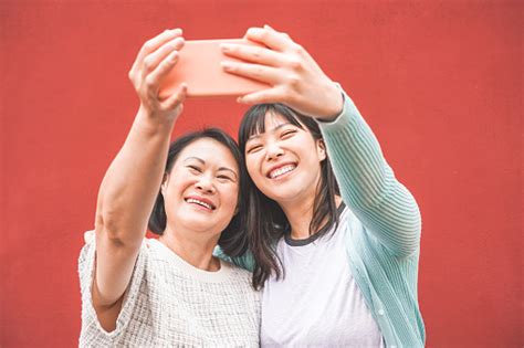 아시아의 어머니과 딸 촬영 Selfie와 스마트폰 용 이야기 앱사랑 어머니 라이프 스타일 기술 및 부드러운 순간의 개념으로 재미