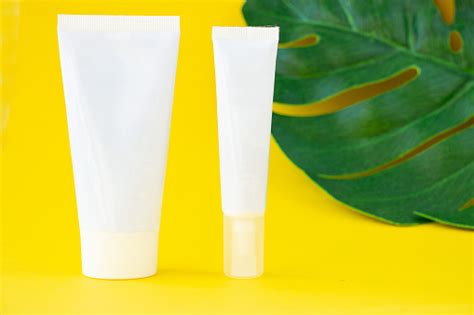 두 개의 빈 화장품 튜브와 노란색 배경에 몬스터의 녹색 잎 텍스트의 공간을 복사합니다 모크 업 브랜딩 미니멀리즘 개념 개념에 대한 스톡 사진 및 기타 이미지 Istock