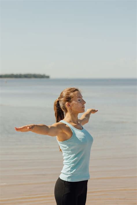 Yoga And Freedom Sporty Woman Does Warm Up On Seashore In Morning With