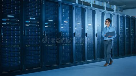 In Data Center Male It Technician Running Maintenance Programme On A Laptop Controls