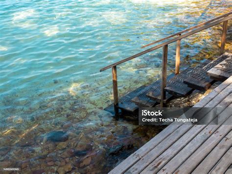 바다로 내려가는 길 해변의 나무 판자 테라스에 있는 빈 나무 계단 바위와 푸른 색이 바닷물을 배경으로 휴식을 취합니다 여름 방학과 휴가 여행 개념 개념에 대한 스톡 사진 및