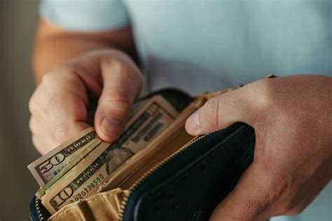 파산 한 남자의 손에 지갑에 작은 종이 달러 지폐와 지갑 비용 관리 비용을 절감할 수 있습니다 빈곤 개념 위기 해임 가죽에 대한