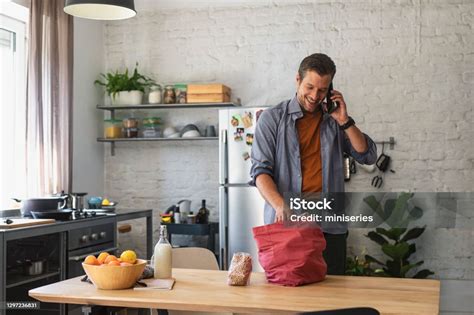 잘 생긴 젊은 남자 는 전화 통화를하는 동안 식료품 가방을 포장 식료품에 대한 스톡 사진 및 기타 이미지 식료품 가정 생활 남자 Istock