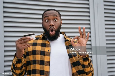 흥분 된 아프리카 계 미국인 남자 온라인 쇼핑에 대 한 신용 카드를 들고 오 기호를 보여주는 거리에 대한 스톡 사진 및 기타