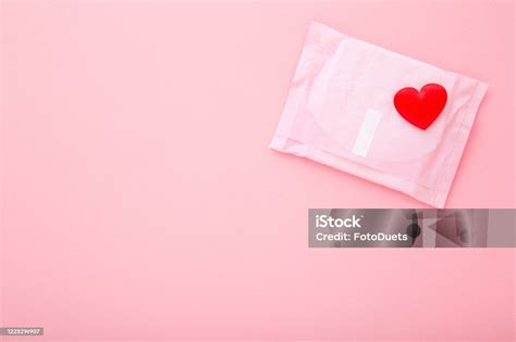 밝은 분홍색 테이블 배경에 위생 수건 팩에 밝은 빨간 마음 파스텔 색상입니다 근접 촬영 텍스트의 빈 장소입니다 하향하 보기 0