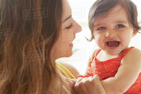 Woman Carrying Baby Girl In Arms Stock Photo Dissolve