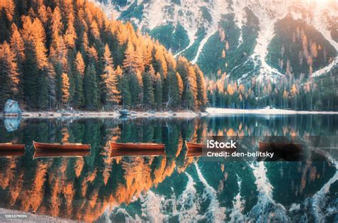 이탈리아 Dolomites에가 일출 Braies 호수에 나무 보트 가 숲 산 반사와 물 화려한 단풍으로 나무와 풍경 이탈리아