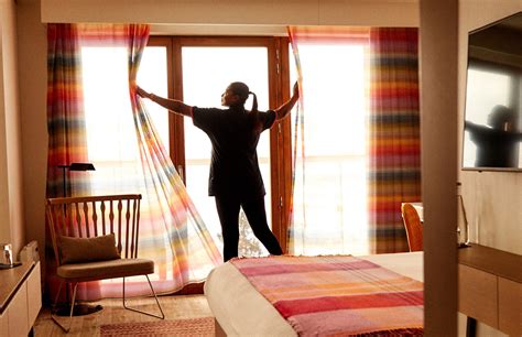 Une Ge Femme De Chambre Ouvrant Les Rideaux Dans La Chambre Dun De