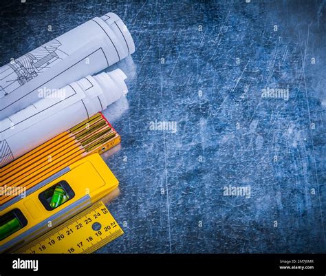 Rolled Blueprints Ruler Construction Level And Wooden Meter On Metallic