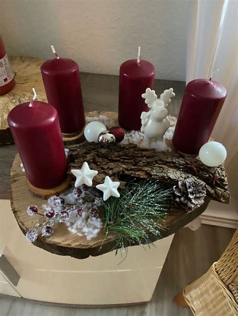A Wooden Table Topped With Red Candles And Other Christmas Decorations On Top Of Wood Slices