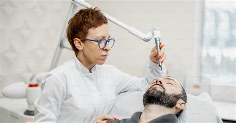 미용실에서 남자에게 레이저 성형 수술을 하는 미용사 노화 방지 비침습적 비수술적 레이저 안면 성형으로 자연스러운 결과 개념