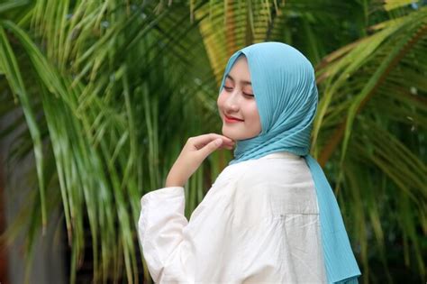 Una Mujer Con Un Hiyab Azul Y Una Camisa Blanca Foto Premium