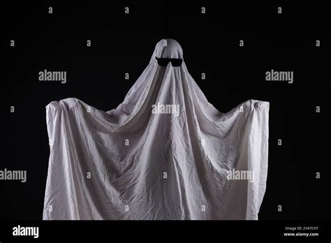 Person In Costume Of Ghost Pointing At Something On Dark Background